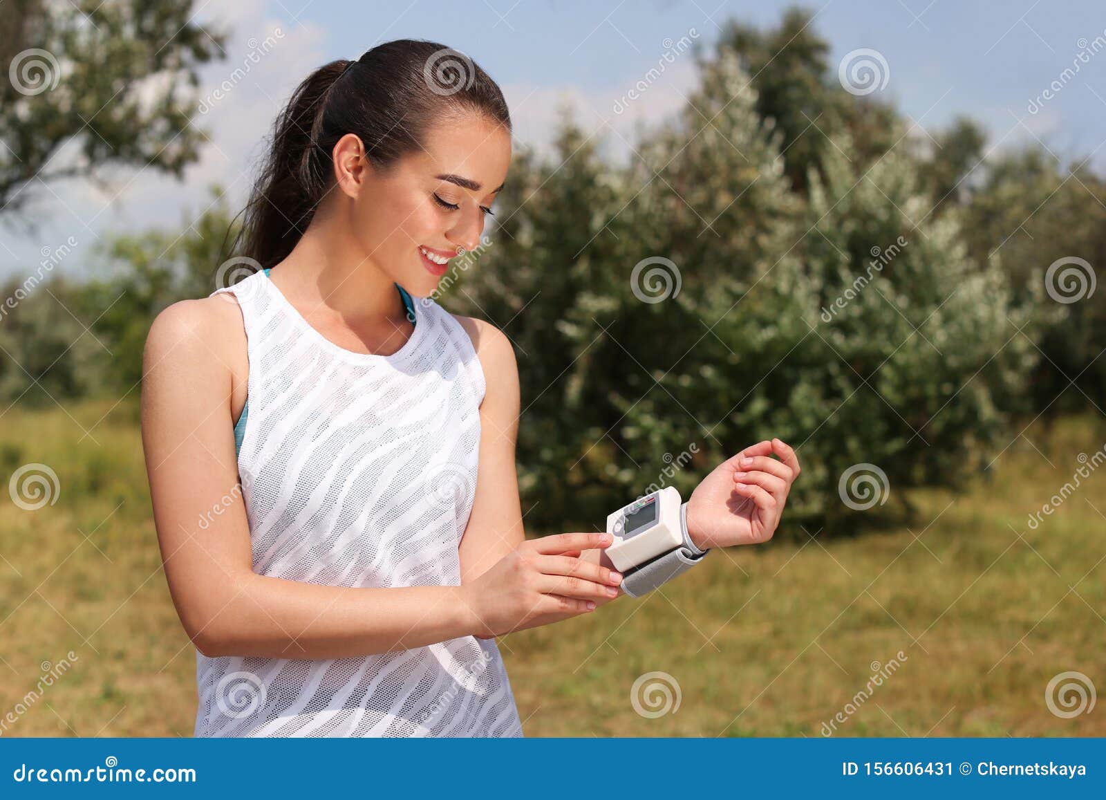 Young Woman Checking Pulse with Medical Device after Training in Park ...