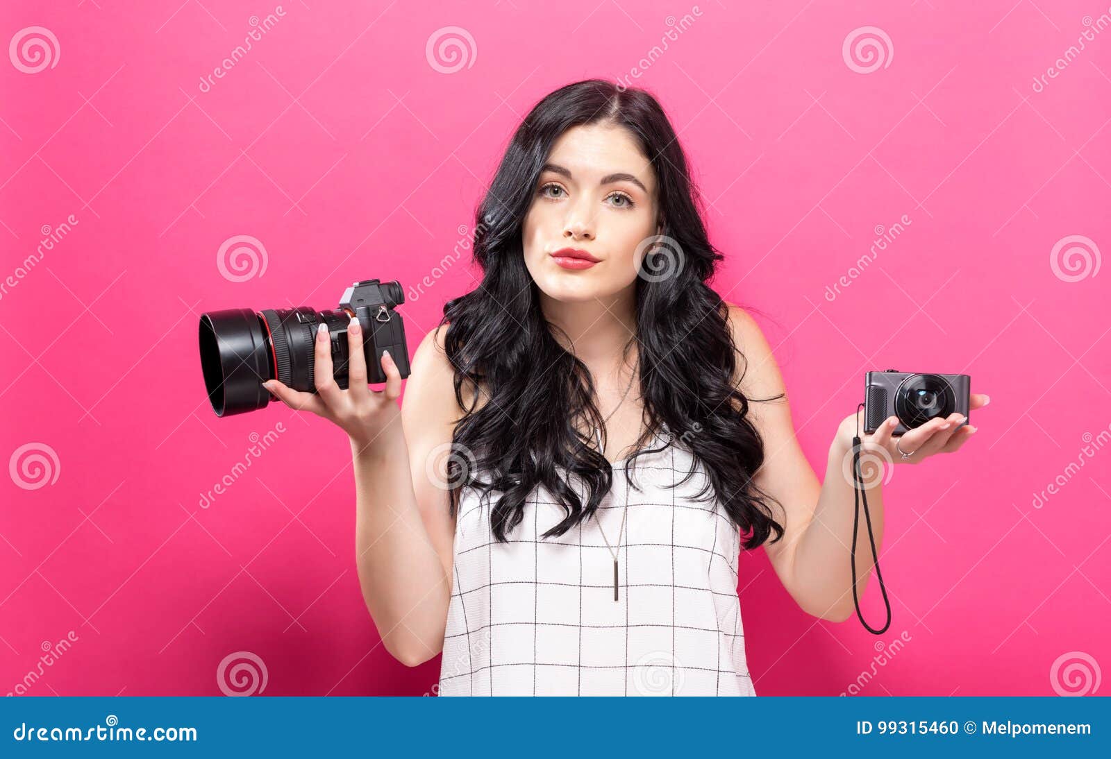 Young Woman Comparing Professional and Compact Cameras Stock Photo ...