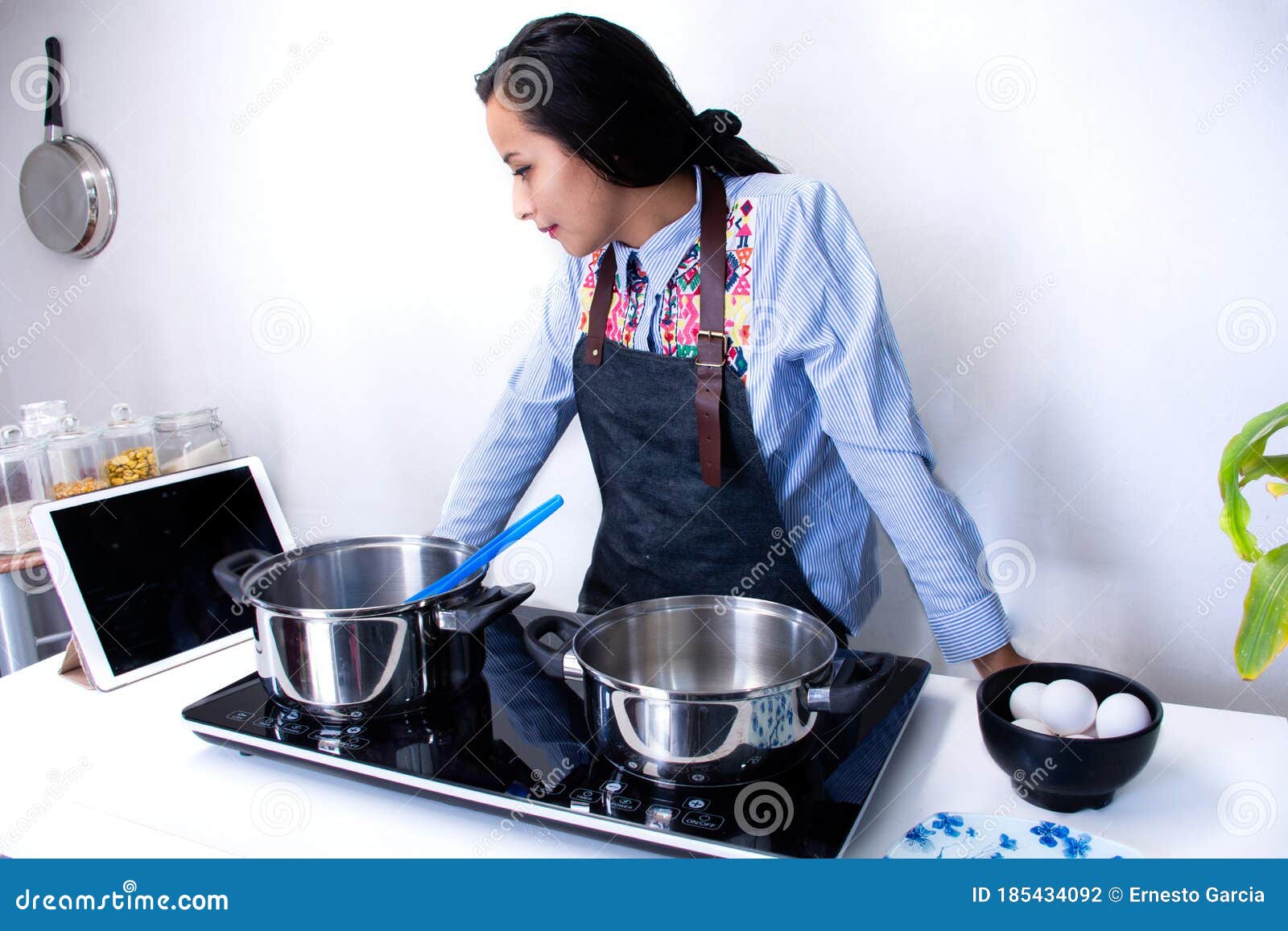 A Young Woman Cooks while Watches a Video on a Tablet Stock Photo ...