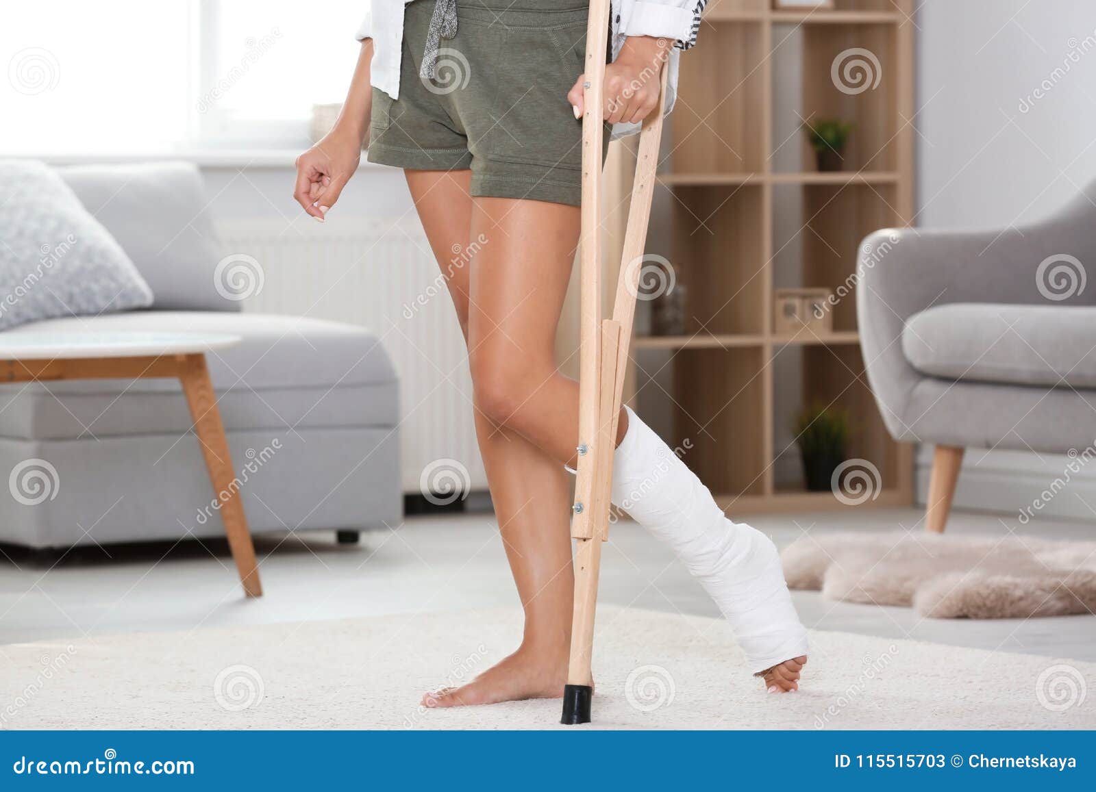 Young Woman With Crutch And Broken Leg In Cast At Home Stock Image