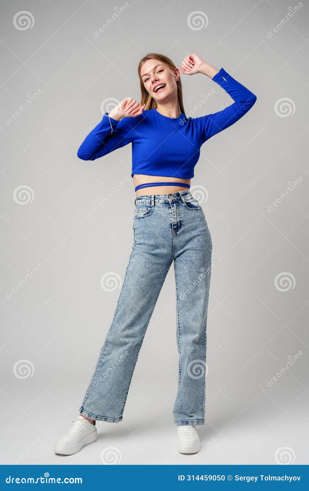 Young Woman Dancing Joyfully Against a Gray Backdrop Stock Photo ...