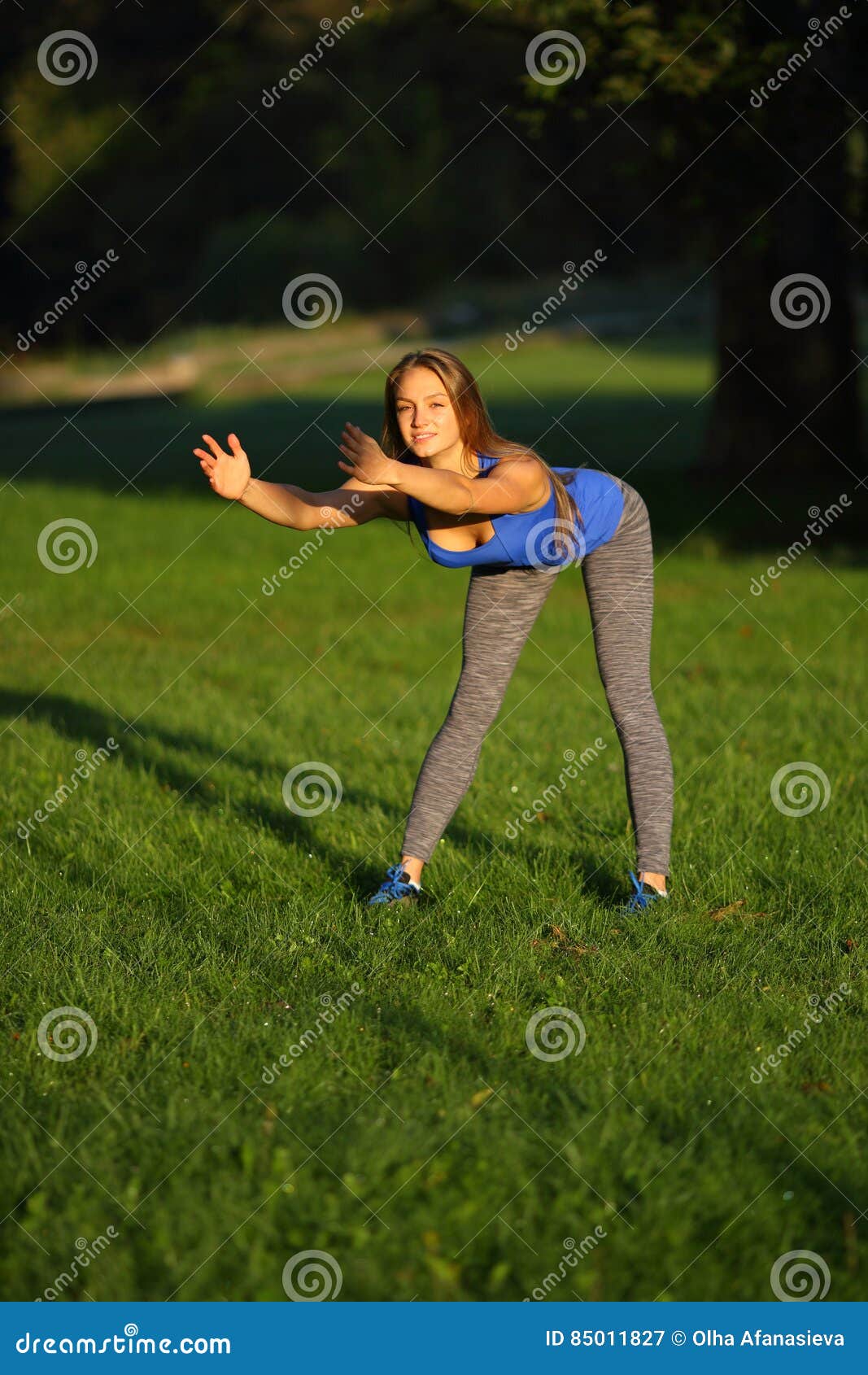 Young Woman Doing Forward Bend on Grass Stock Image - Image of green ...
