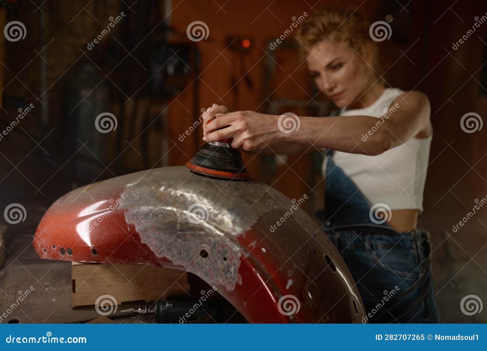 Young Woman Doing Hard Job at Motorcycle Garage Using Grinder Stock ...