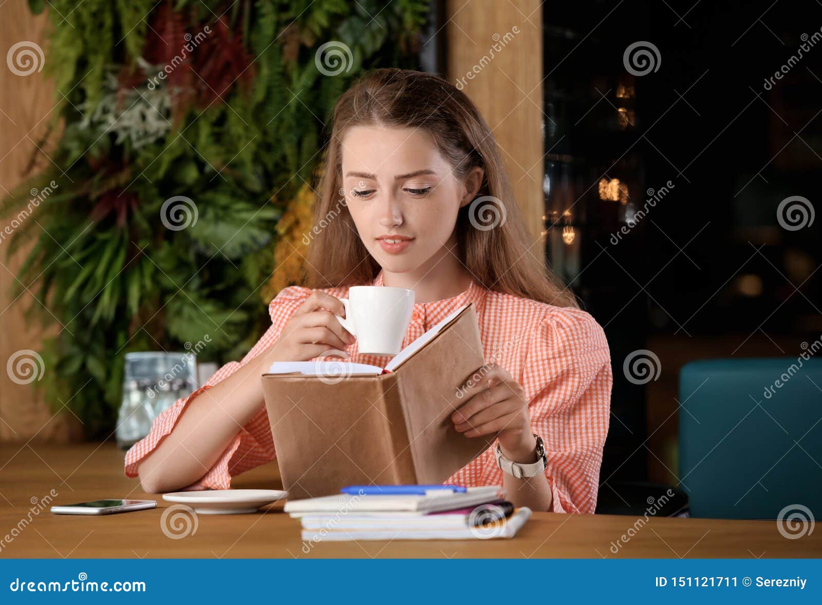 Young Woman Drinking Coffee while Reading Book in Cafe Stock Image ...