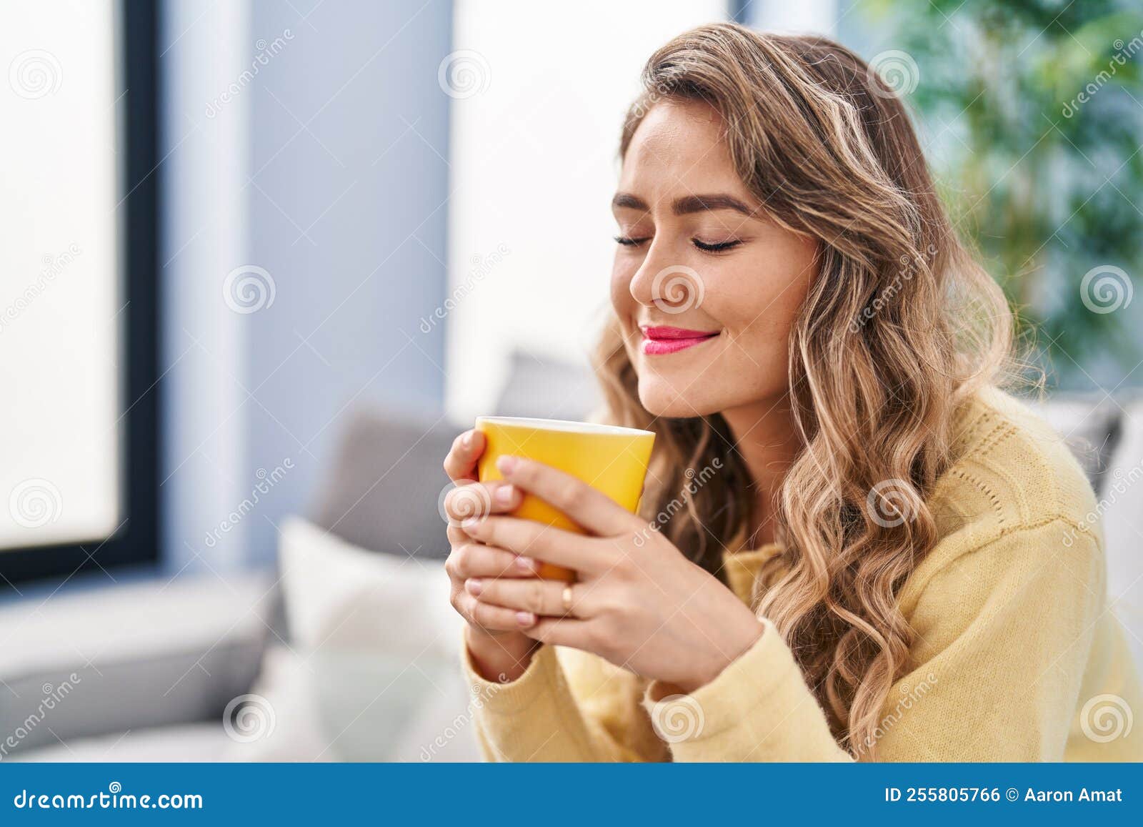 Young Woman Drinking Coffee Sitting on Sofa at Home Stock Photo - Image ...