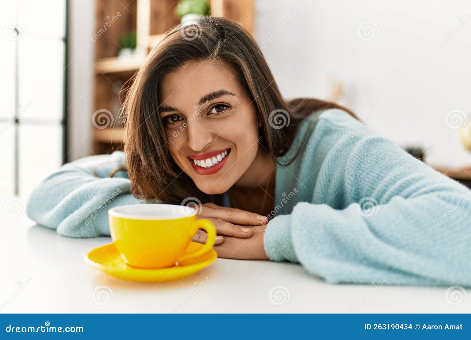 Young Woman Drinking Coffee Sitting on Table at Home Stock Photo ...