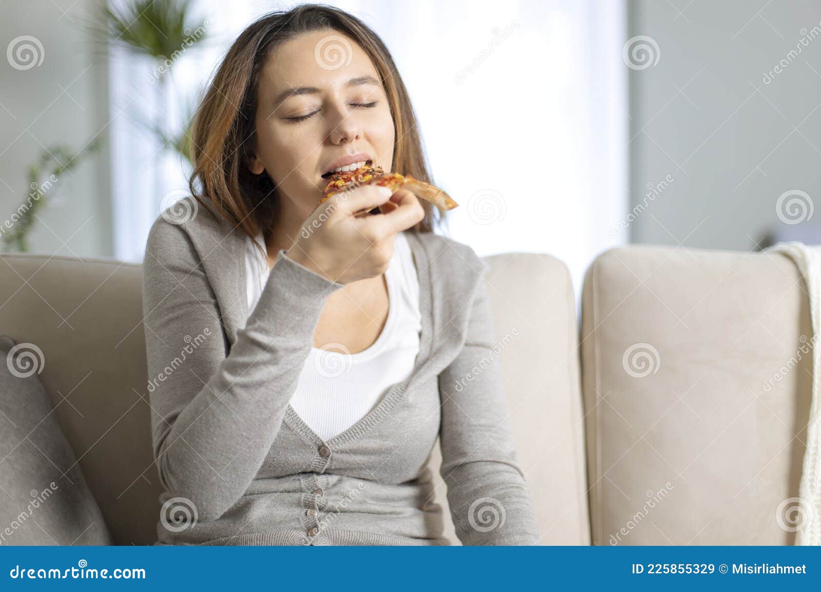 Beautiful Young Girl Eating A Slice Of Pizza At Home Stock Image