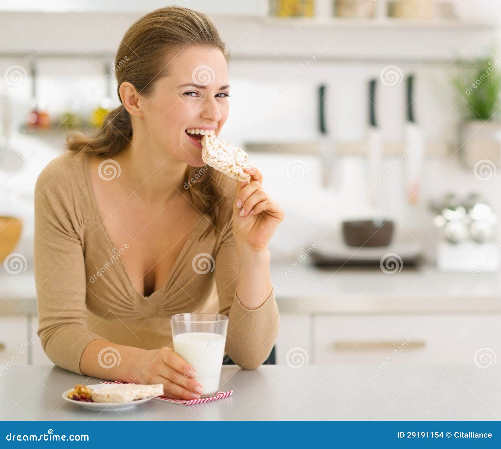 Young Woman Eating Snacks in Modern Kitchen Stock Photo - Image of ...