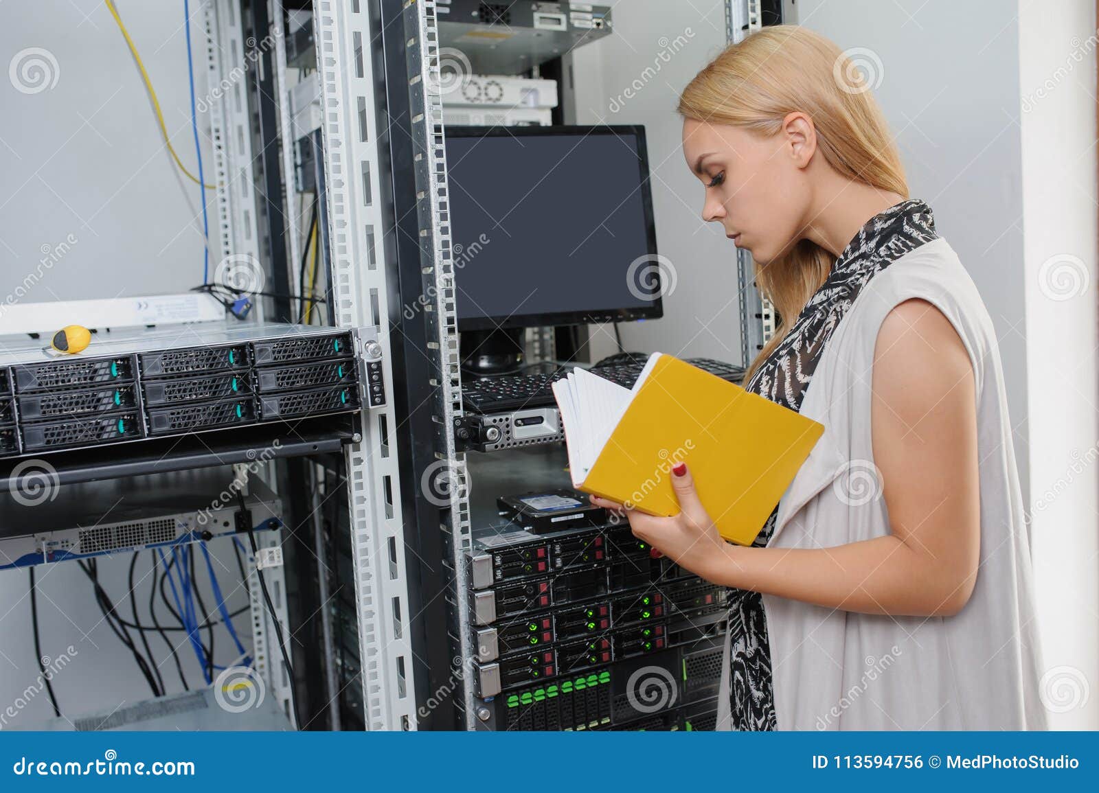 Young Woman Engineer it between the Server Racks in the Data Center ...