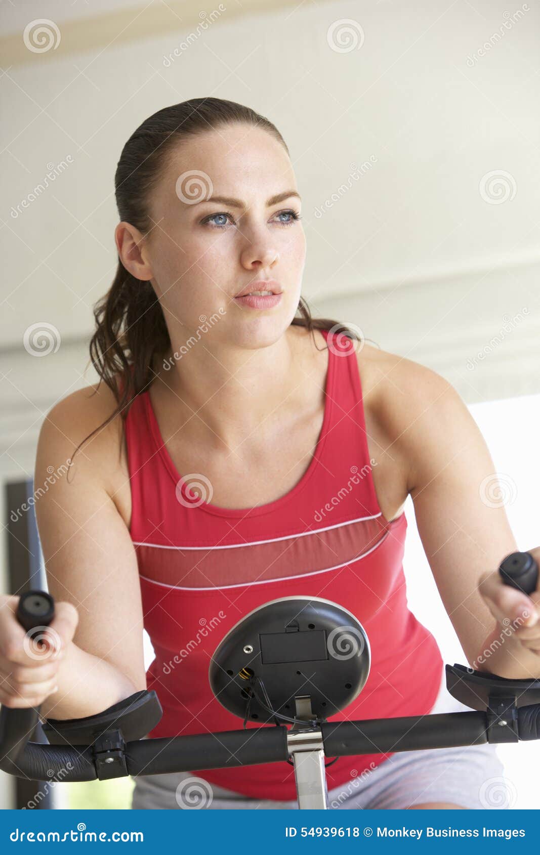Young Woman on Exercise Bike Stock Photo - Image of active, exercising ...
