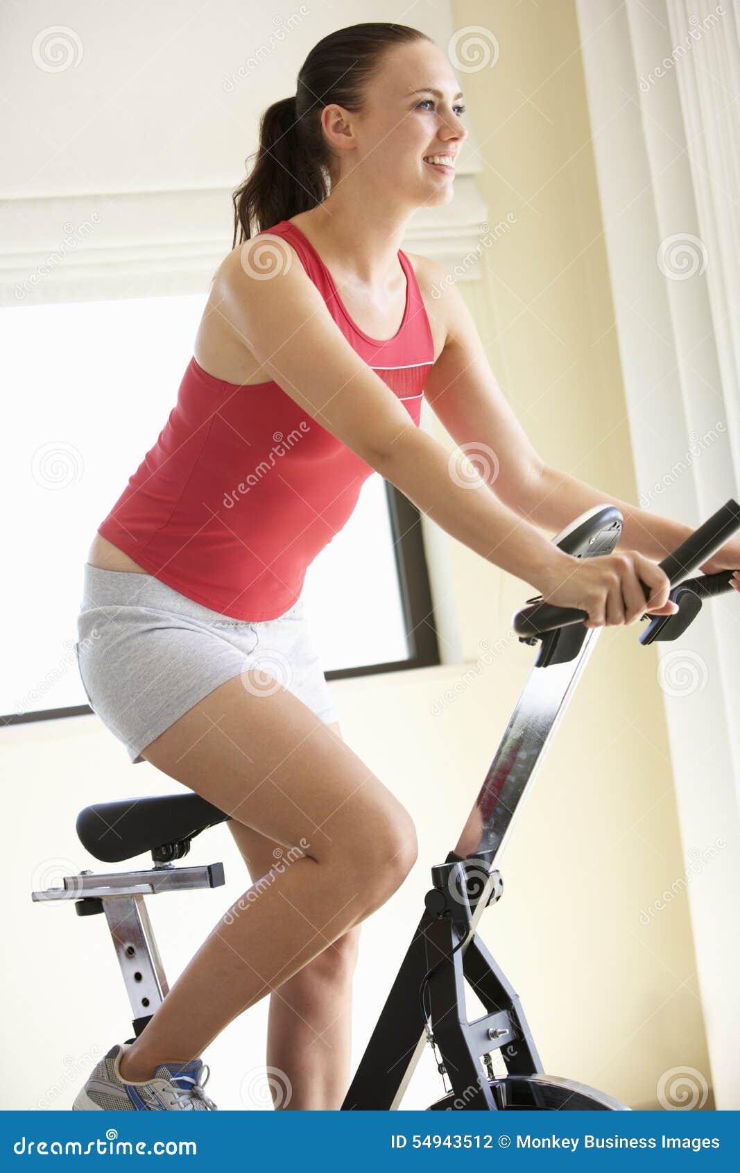 Young Woman on Exercise Bike Stock Photo - Image of healthy, young ...