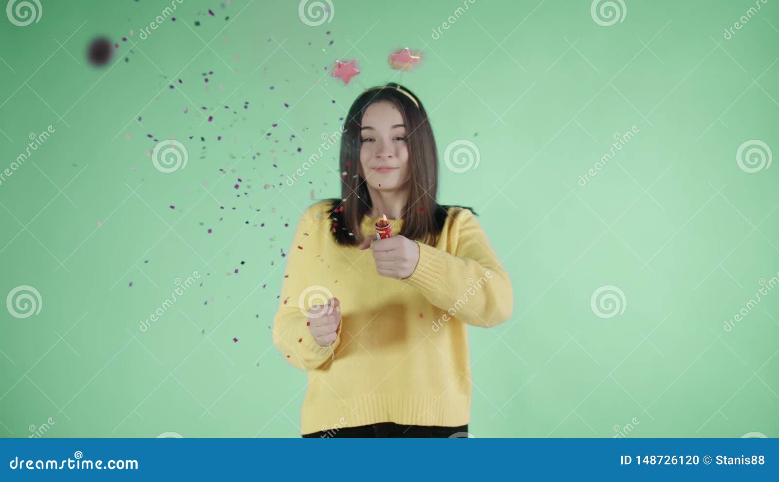 Young Woman Exploding Confetti Cracker on a Green Background. Stock ...