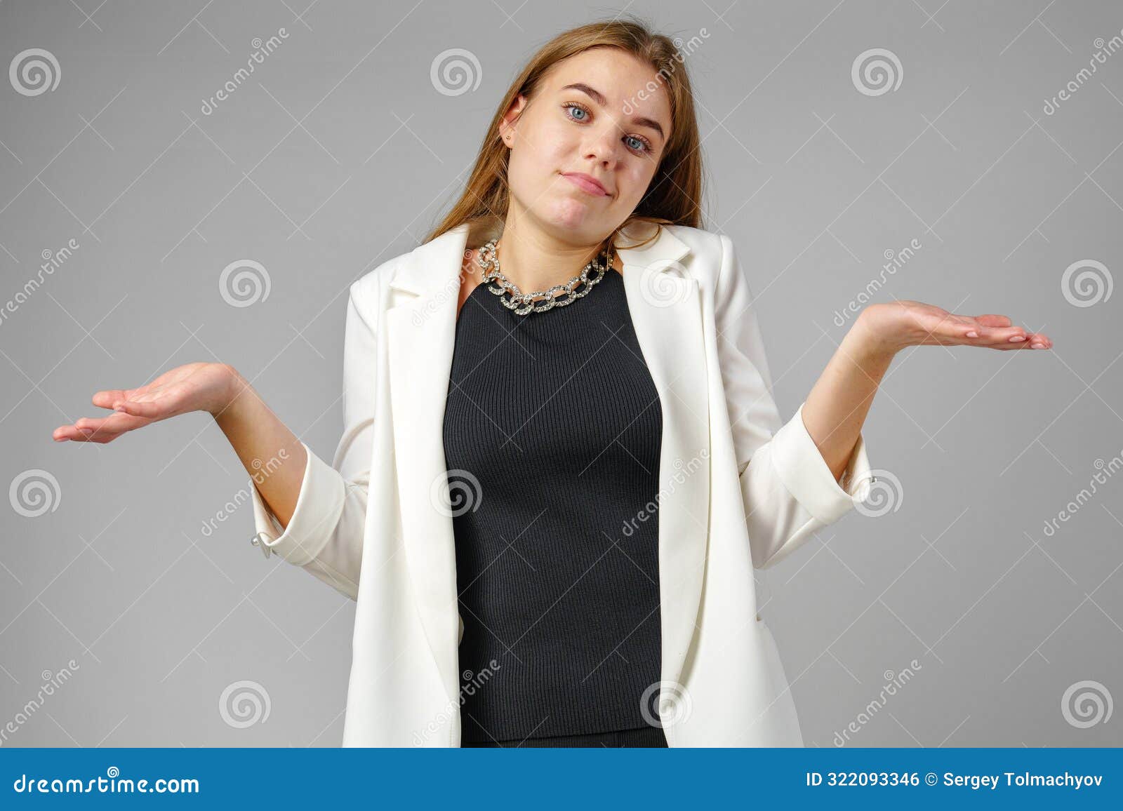 Young Woman Expressing Confusion with Hands Raised Against a Grey ...