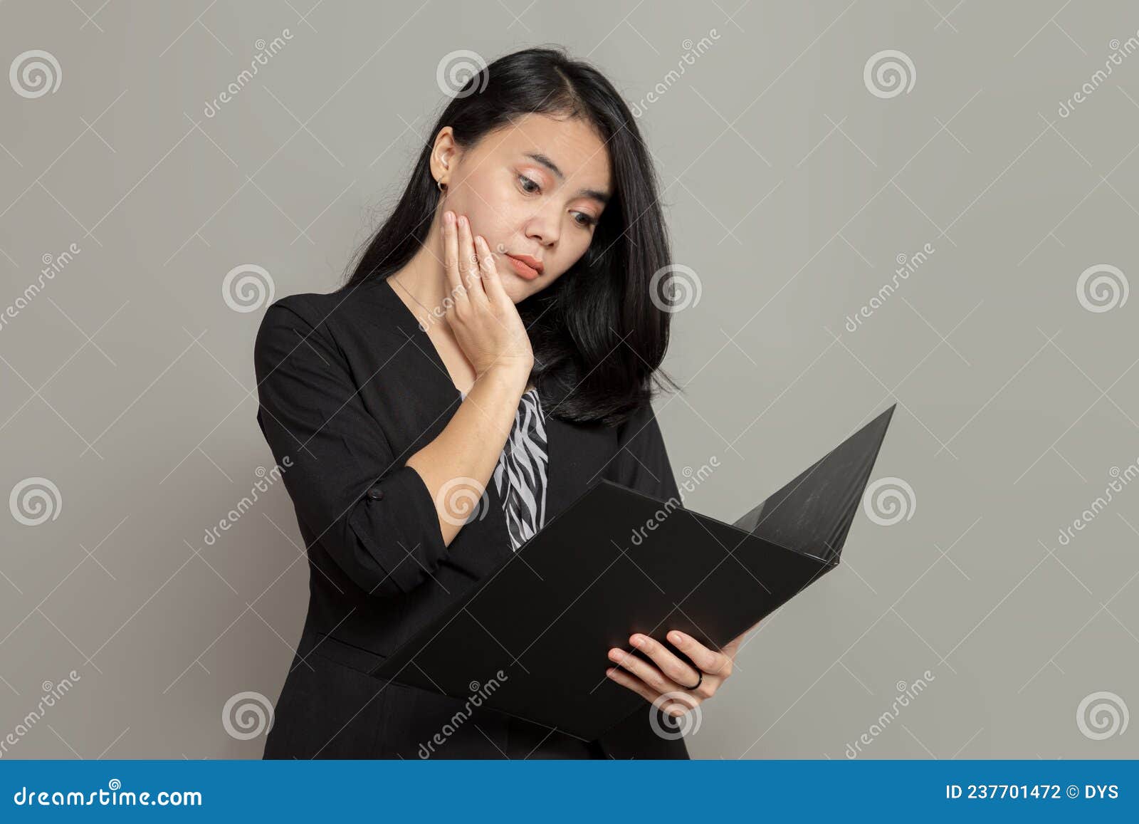 Young Woman with a Flat Facial Expression while Looking at and Holding ...