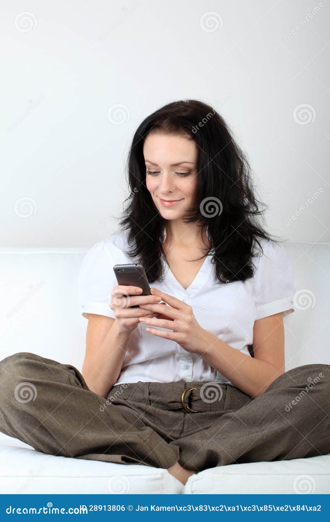Young Woman with Happy Expression Looking at Message on Her Cell Phone ...