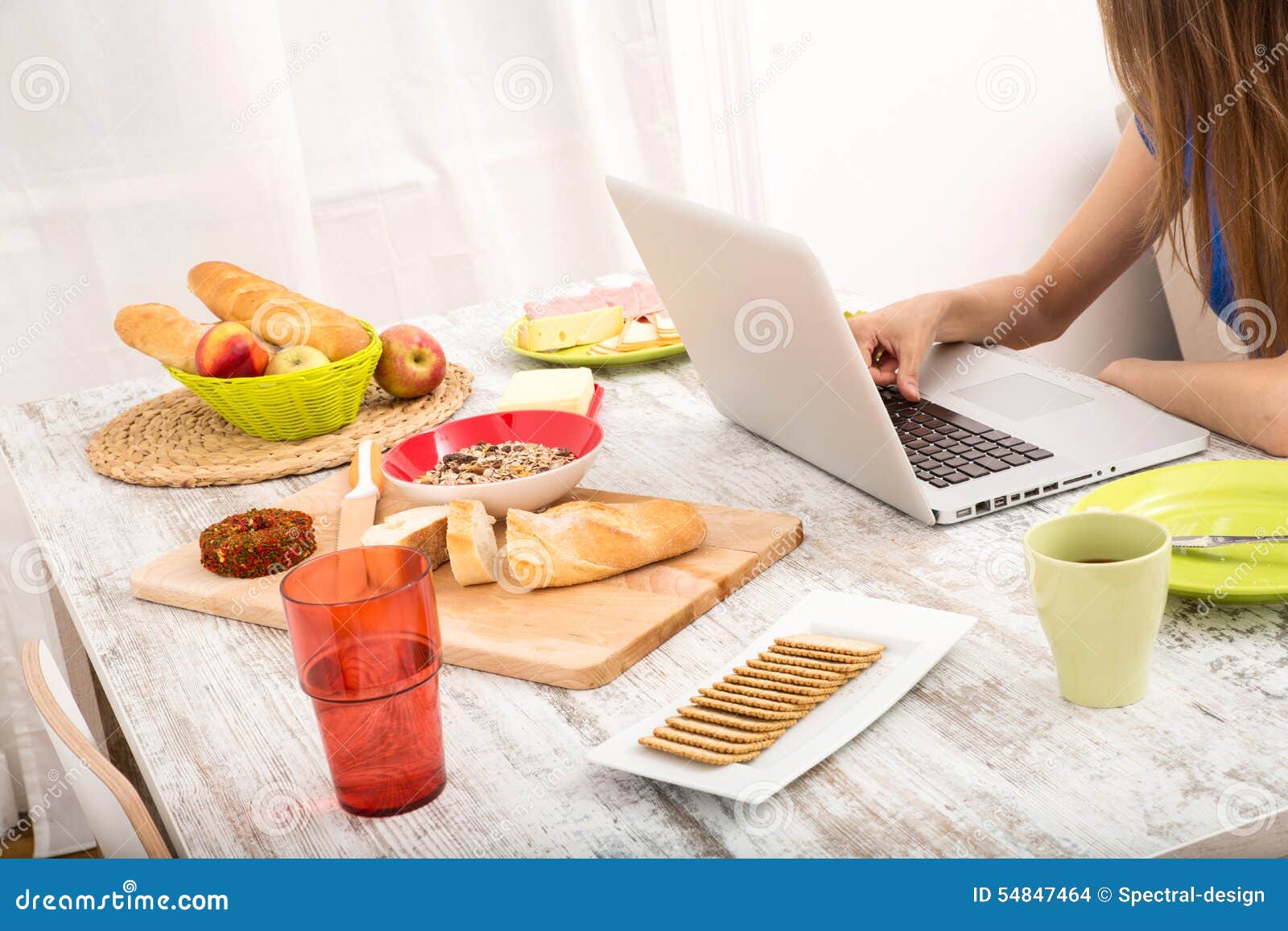Young Woman Having Breakfast while Using a Laptop Computer Stock Photo ...