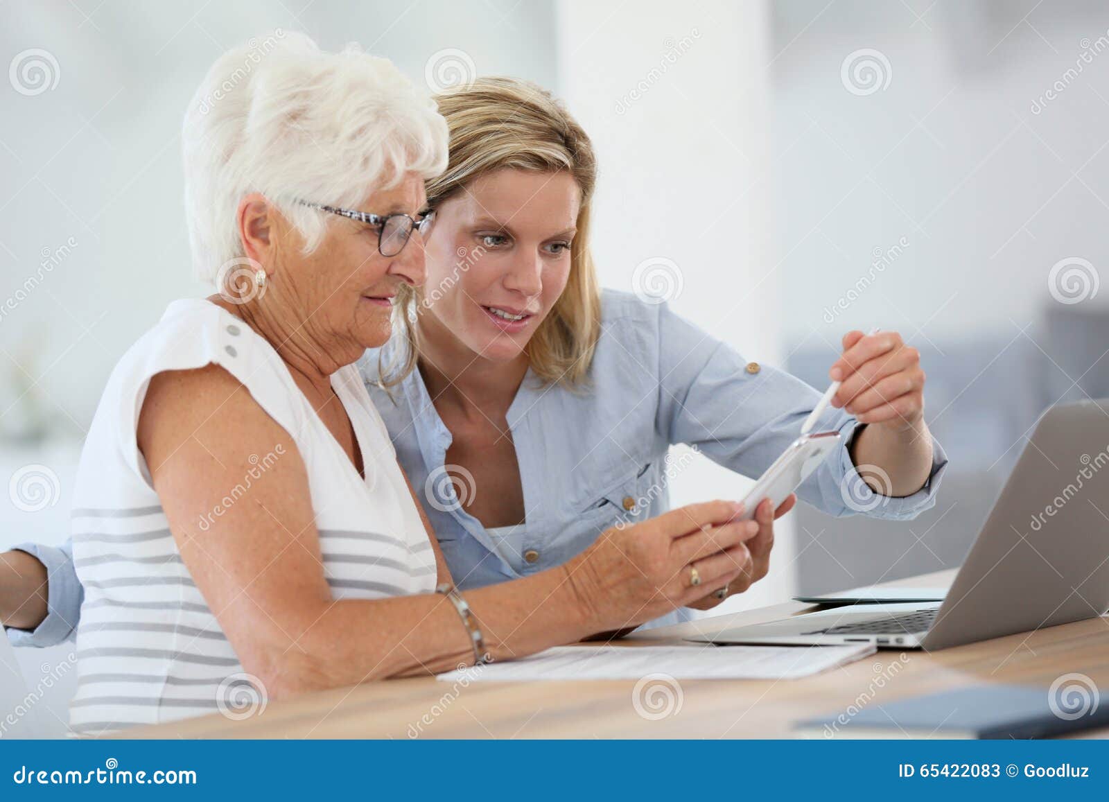 Young Woman Helping Elderly Using Smartphone Stock Image - Image of ...