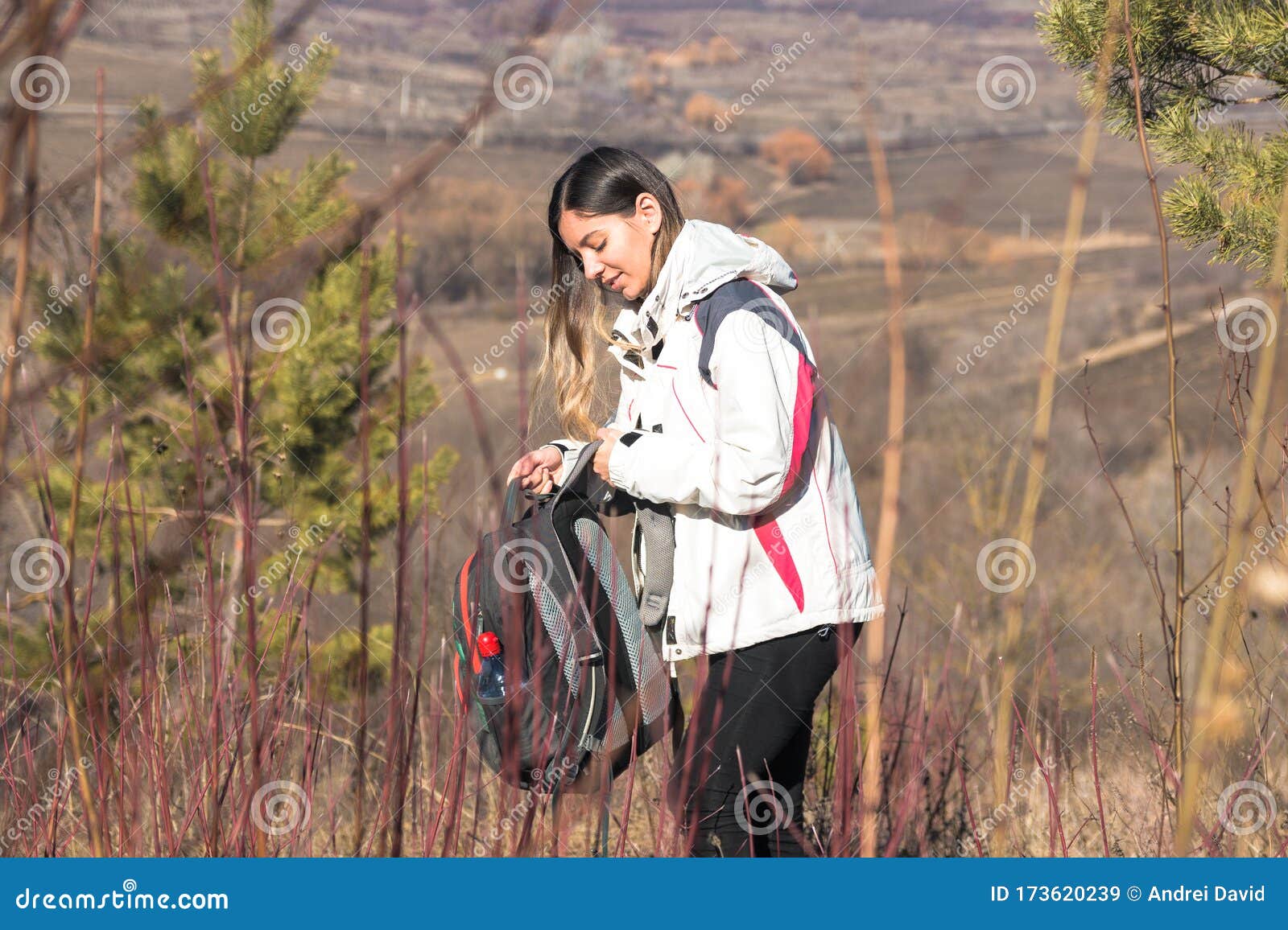 Young Woman Hiker Putting a Backpack on Shoulder on Hill in Spring Time ...