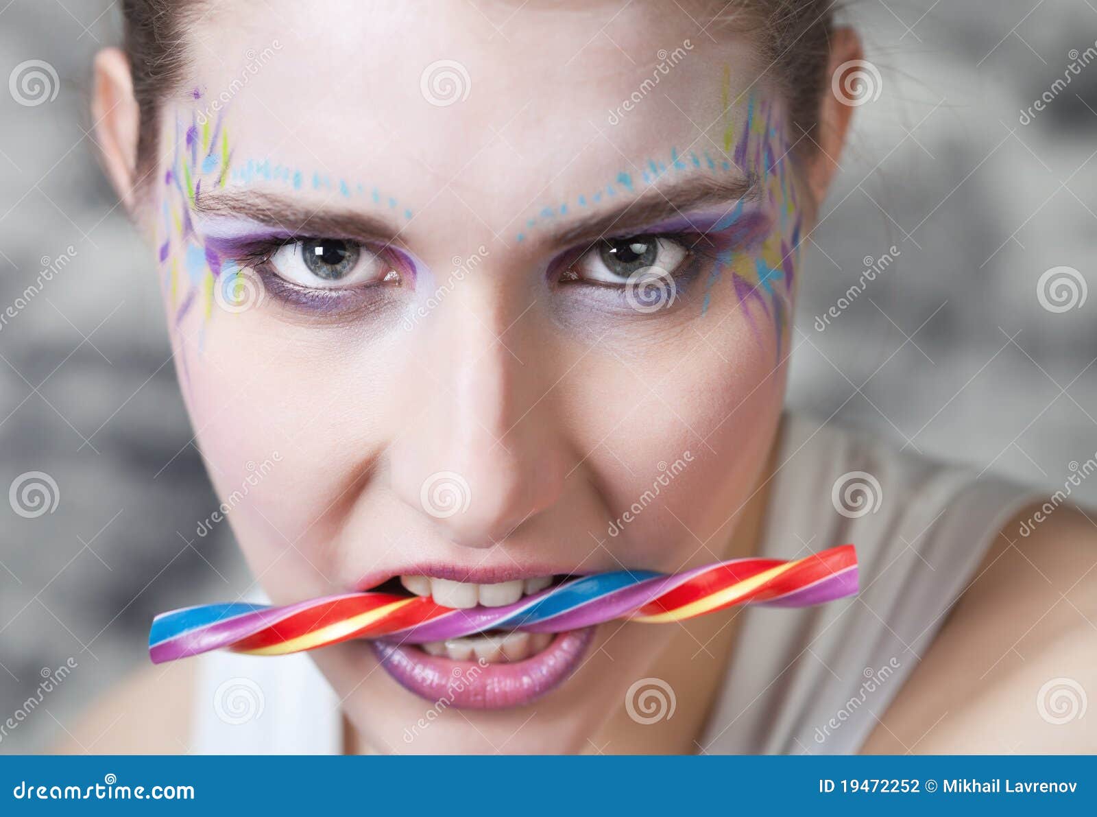 Young Woman Holding Candy in Her Teeth Stock Photo - Image of ...