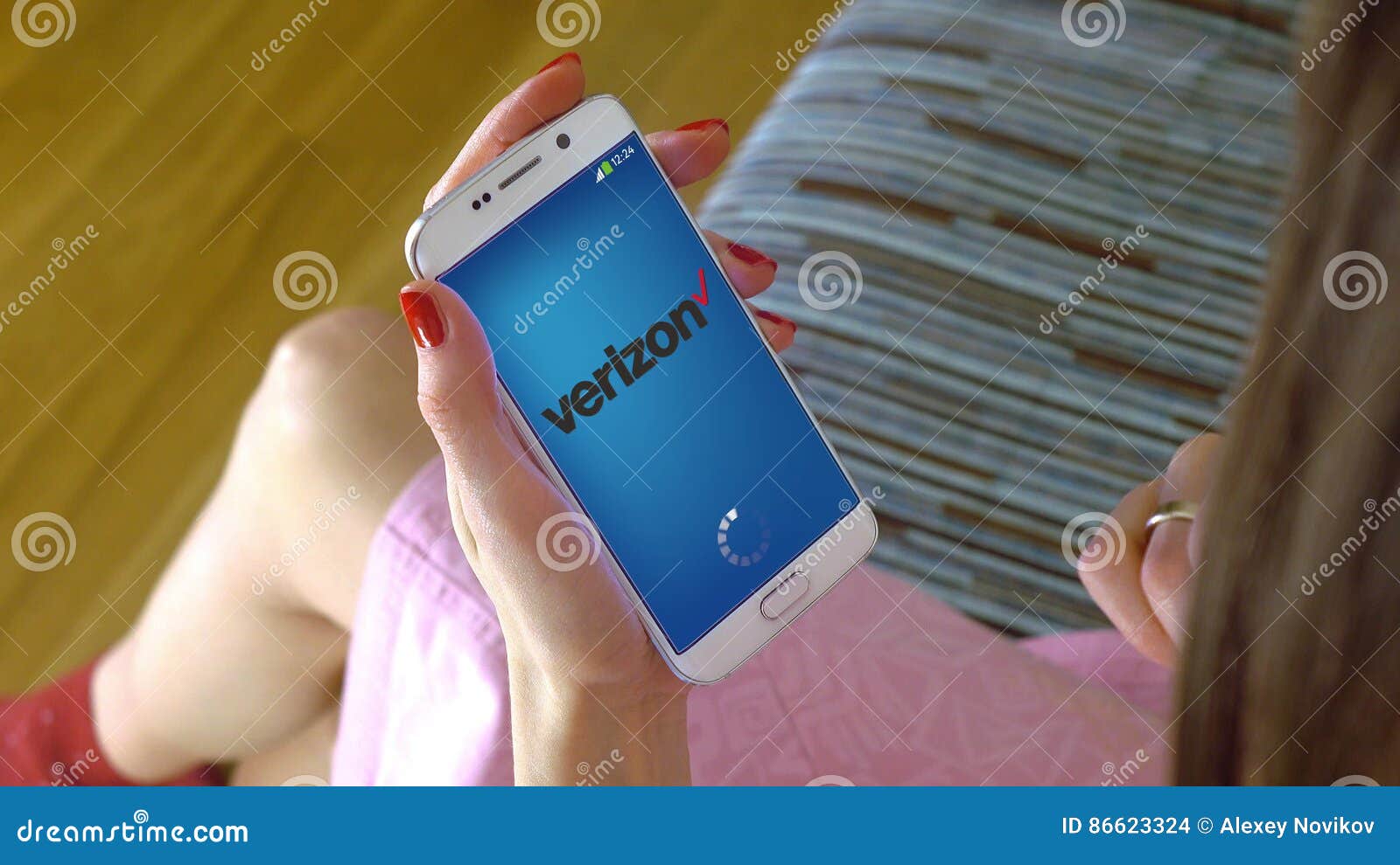 Young Woman Holding a Cell Phone with Loading Verizon Mobile App ...