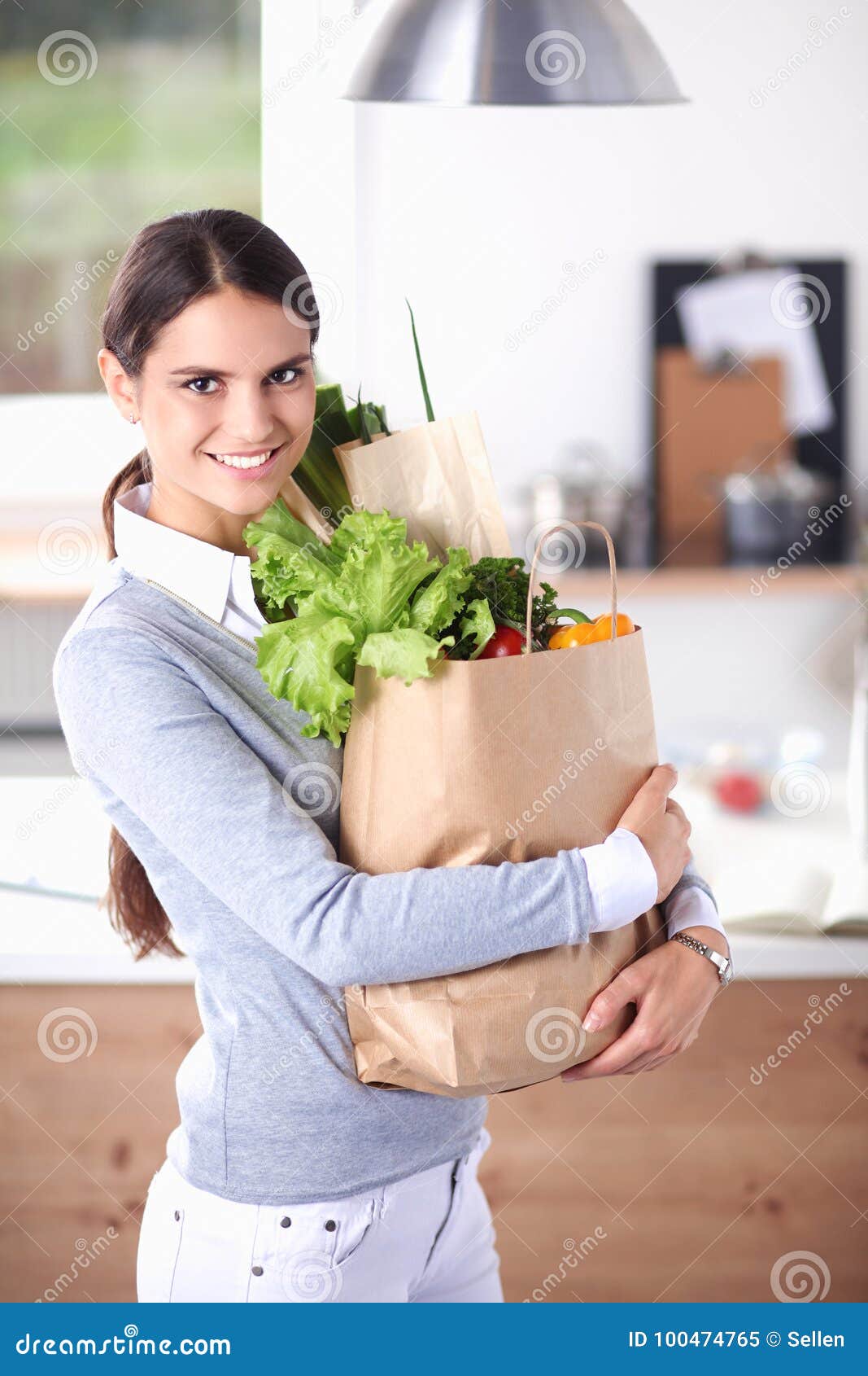 Young Woman Holding Grocery Shopping Bag with Vegetables . Standing in ... Young Woman Holding Grocery Shopping Bag with Vegetables . Standing in ...