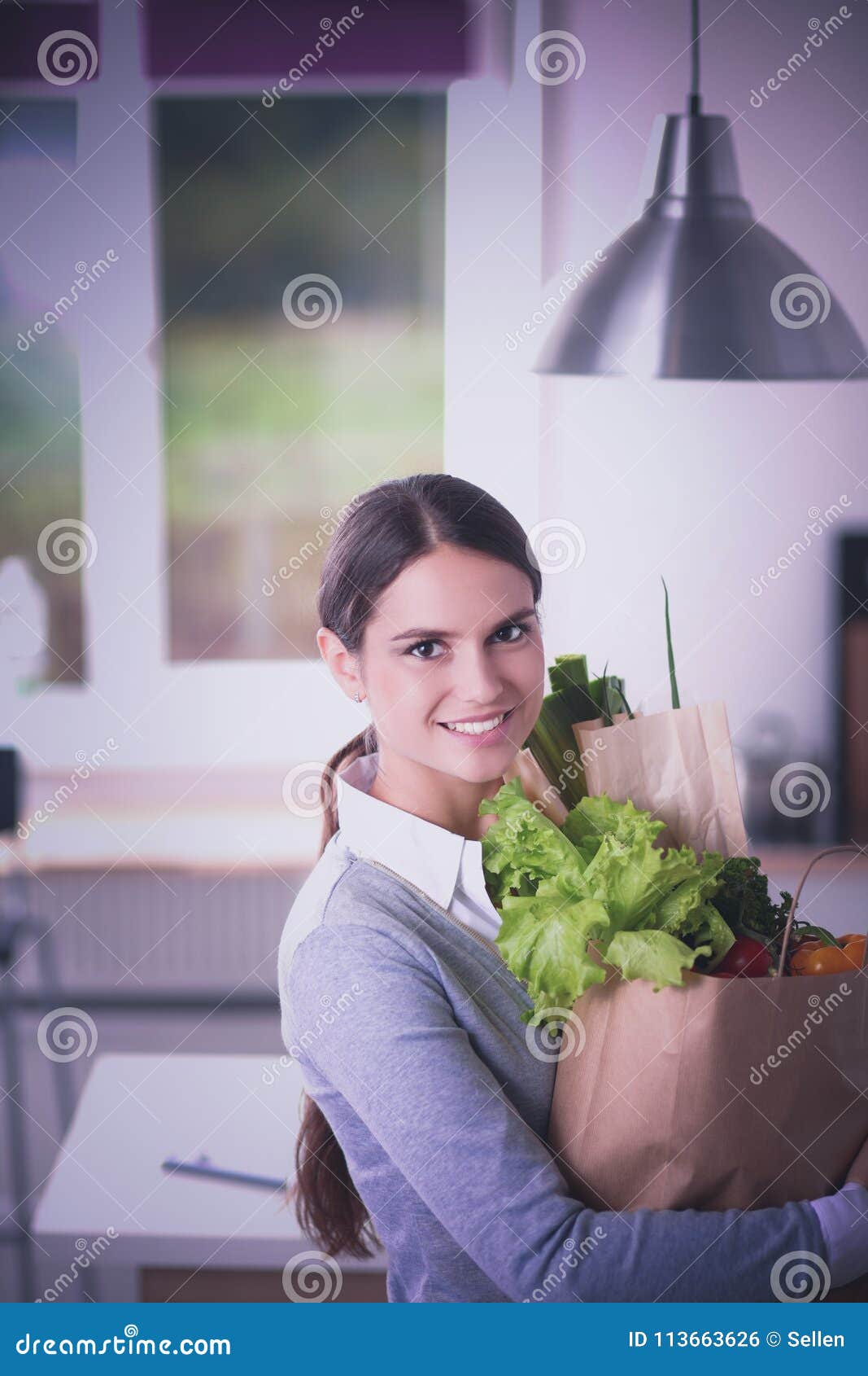 Young Woman Holding Grocery Shopping Bag with Vegetables . Standing in ... Young Woman Holding Grocery Shopping Bag with Vegetables . Standing in ...