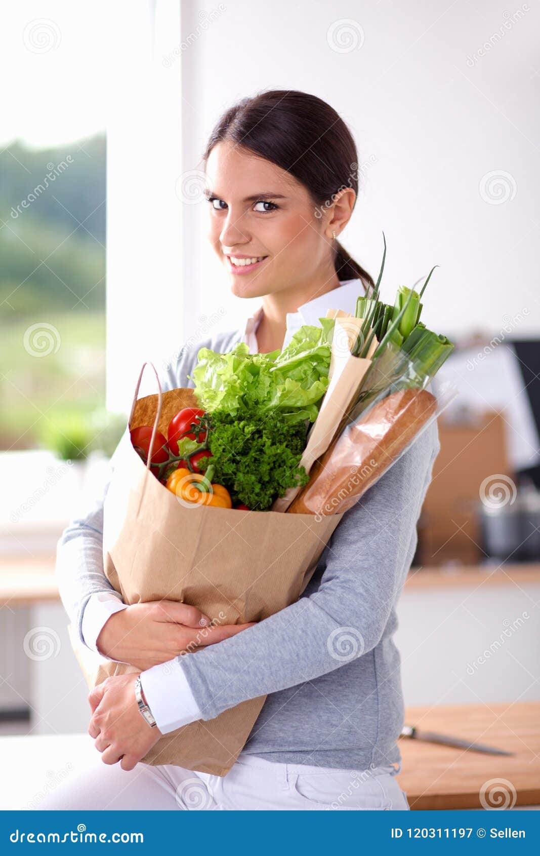 Young Woman Holding Grocery Shopping Bag with Vegetables . Standing in ... Young Woman Holding Grocery Shopping Bag with Vegetables . Standing in ...