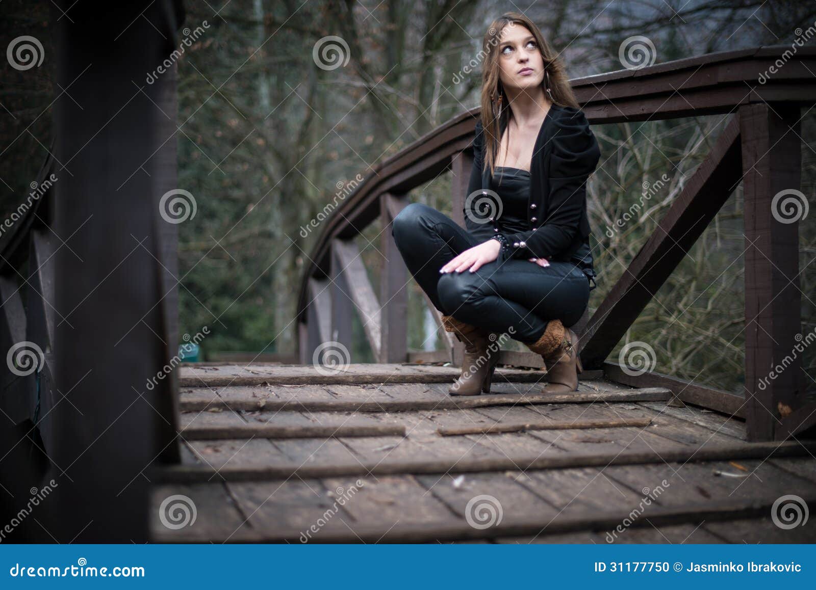 Young Woman in Jacket Crouch at Bridge Stock Photo - Image of ...