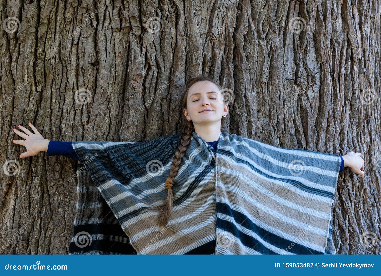 Young Woman Leaned Her Back Against The Trunk Of A Large Tree Closed