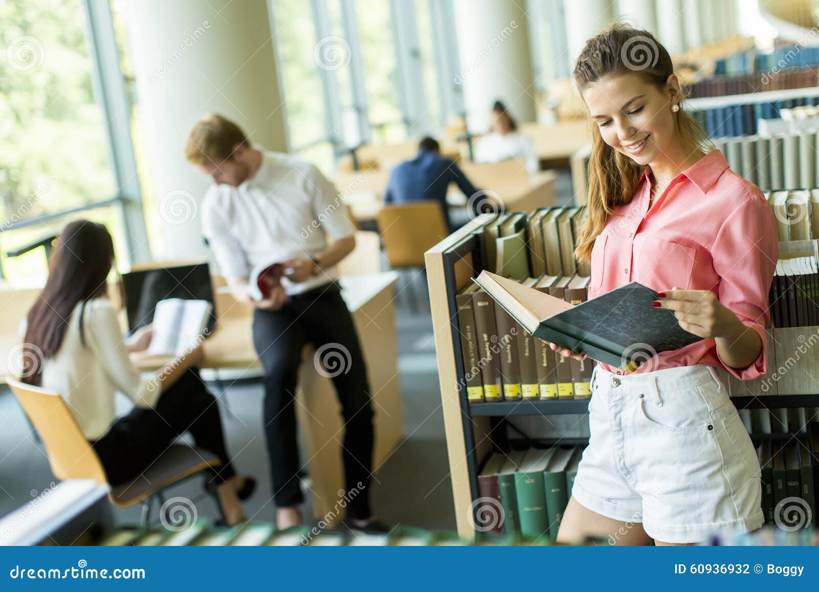 Young woman in the library stock photo. Image of university - 60936932