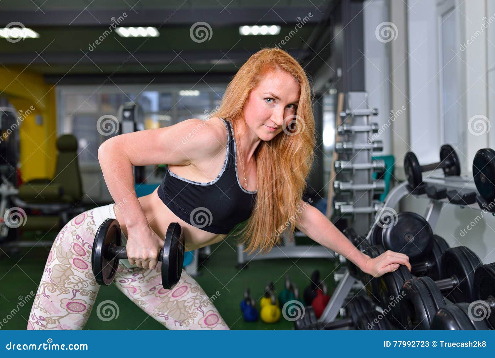 Young Woman Lifting Heavy Weight Exercise With Dumbbells On Broadest