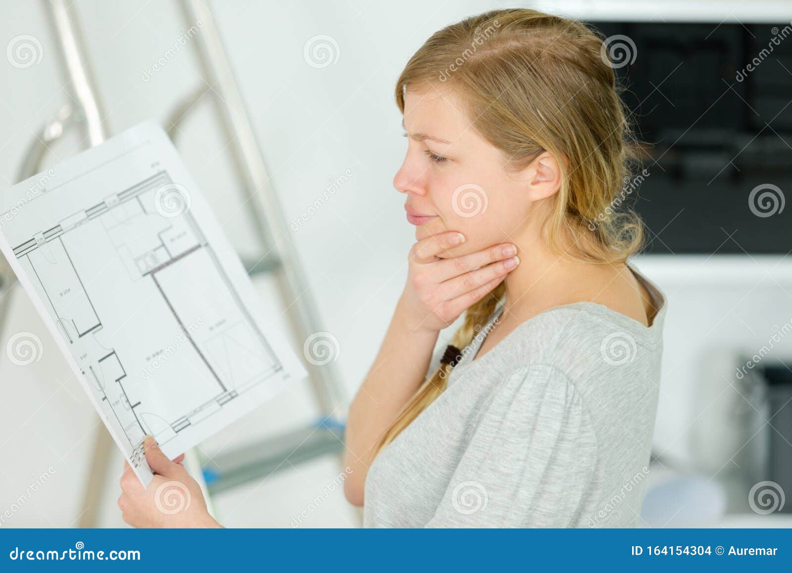 Young Woman Looking at Floorplan Stock Photo - Image of precision, plan ...