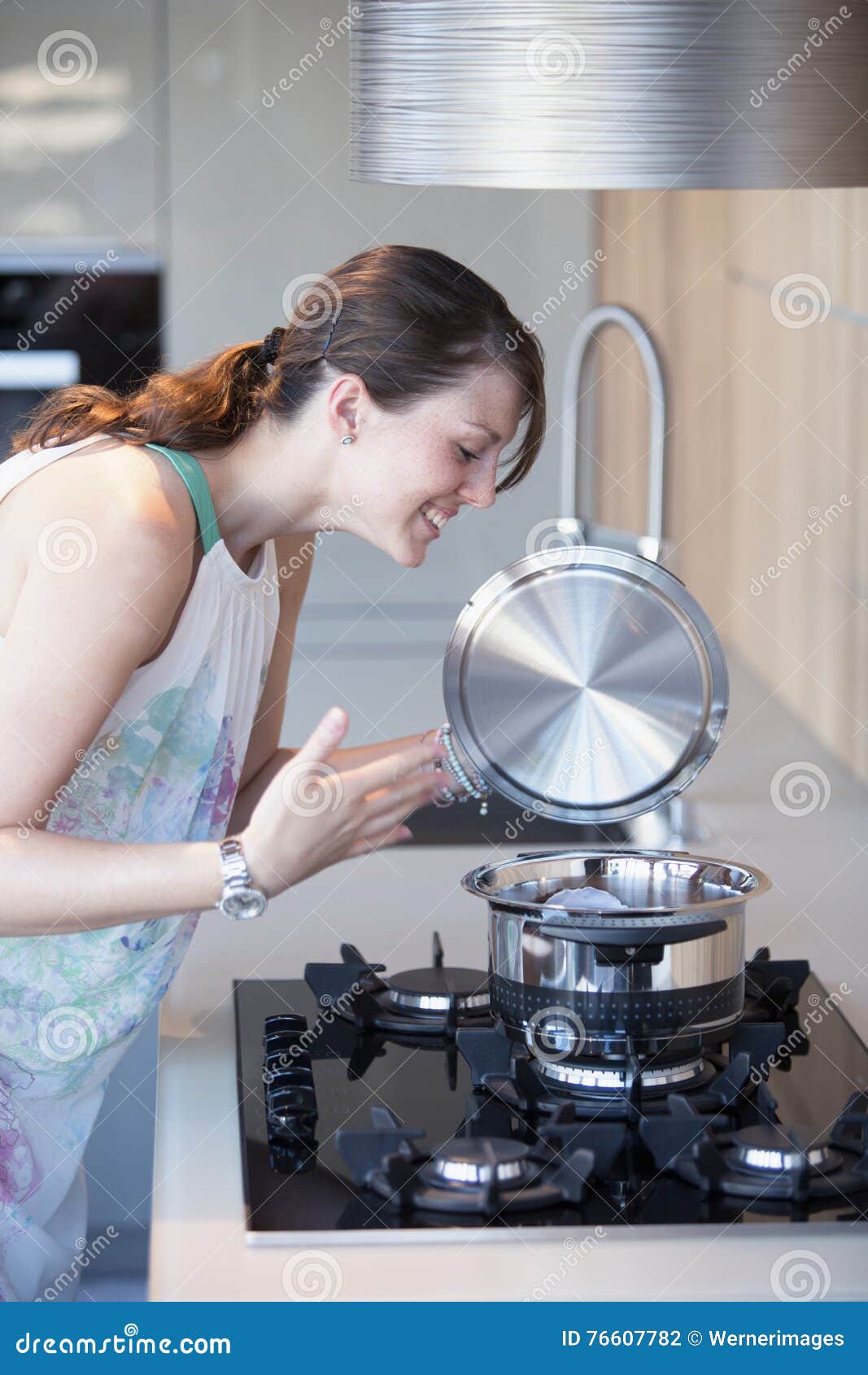 Young Woman Looking Inside of Pot in Kitchen Stock Photo - Image of ...