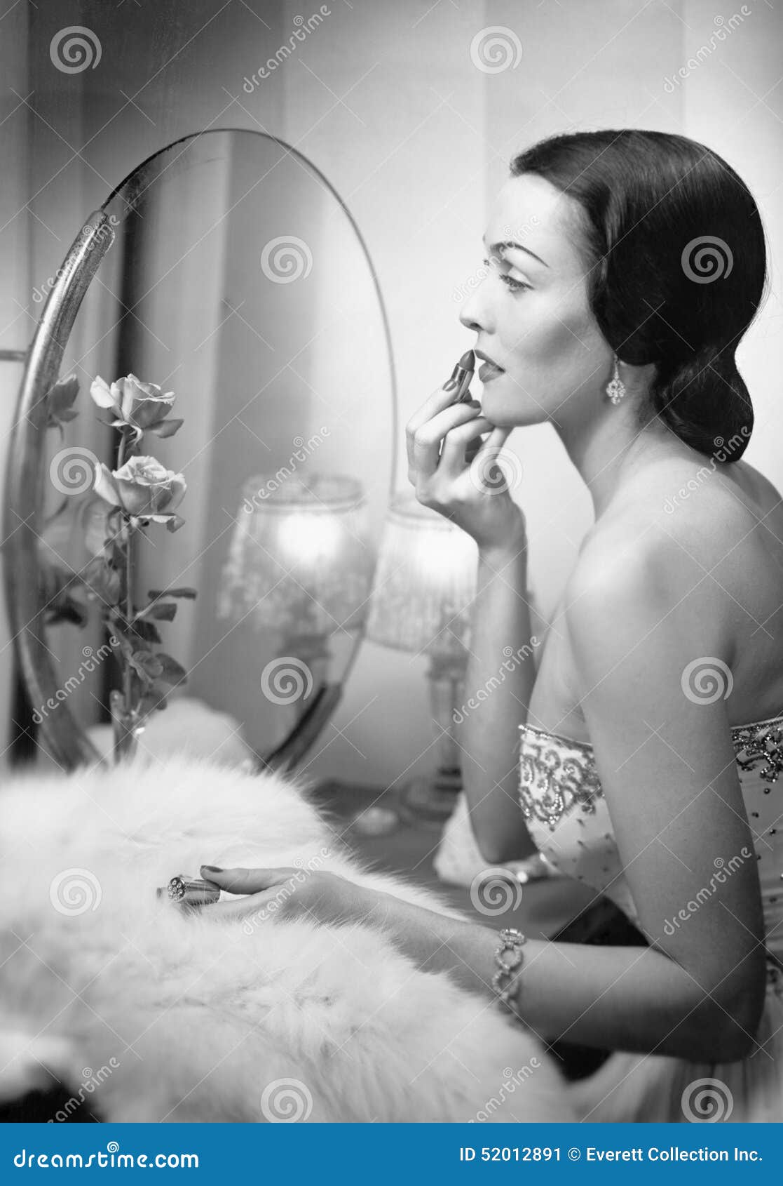 Young Woman Looking into a Mirror and Putting on Make Up Stock Image ...