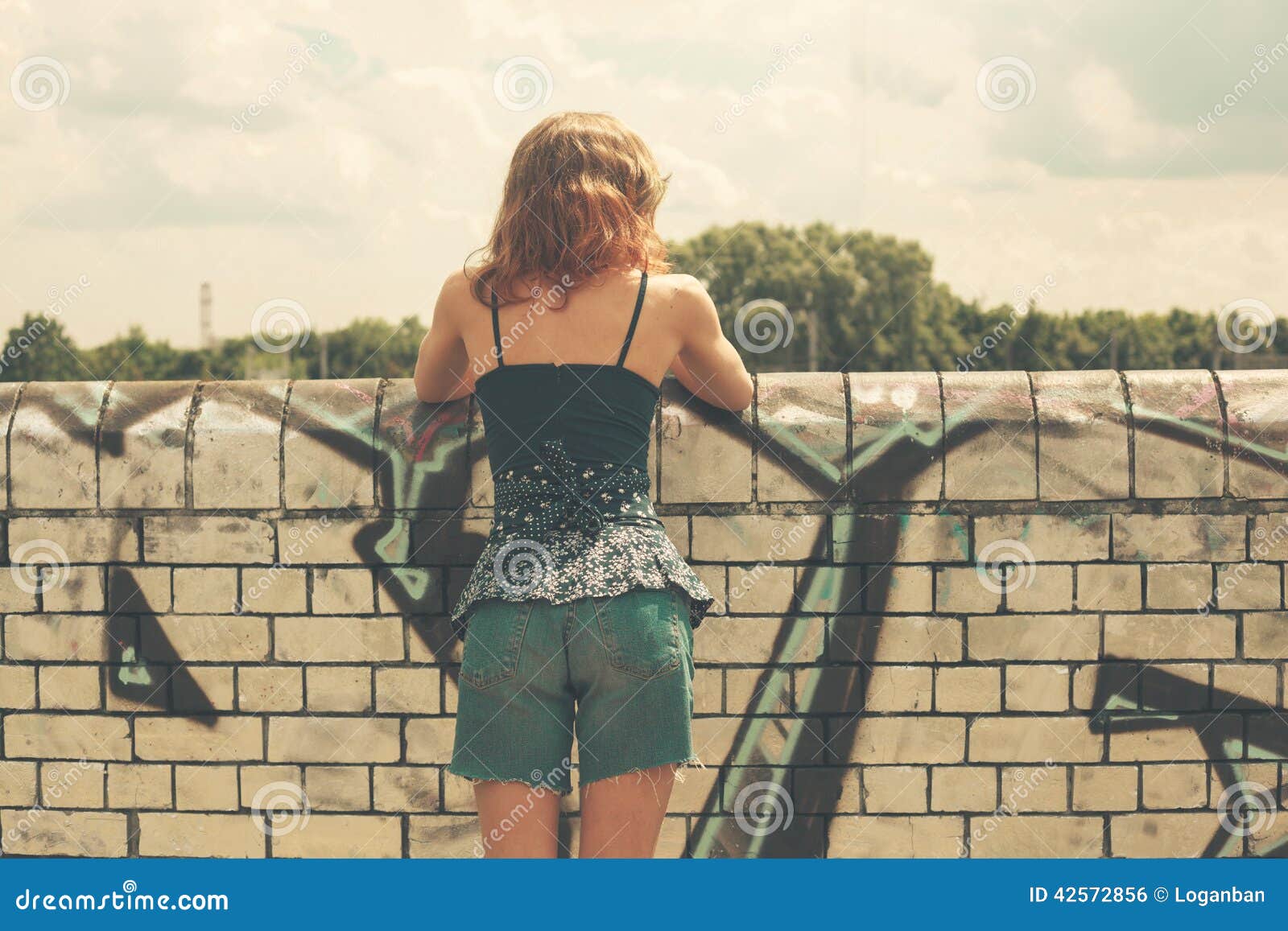 Young Woman Looking Over Wall Stock Photo - Image of walking, wall ...