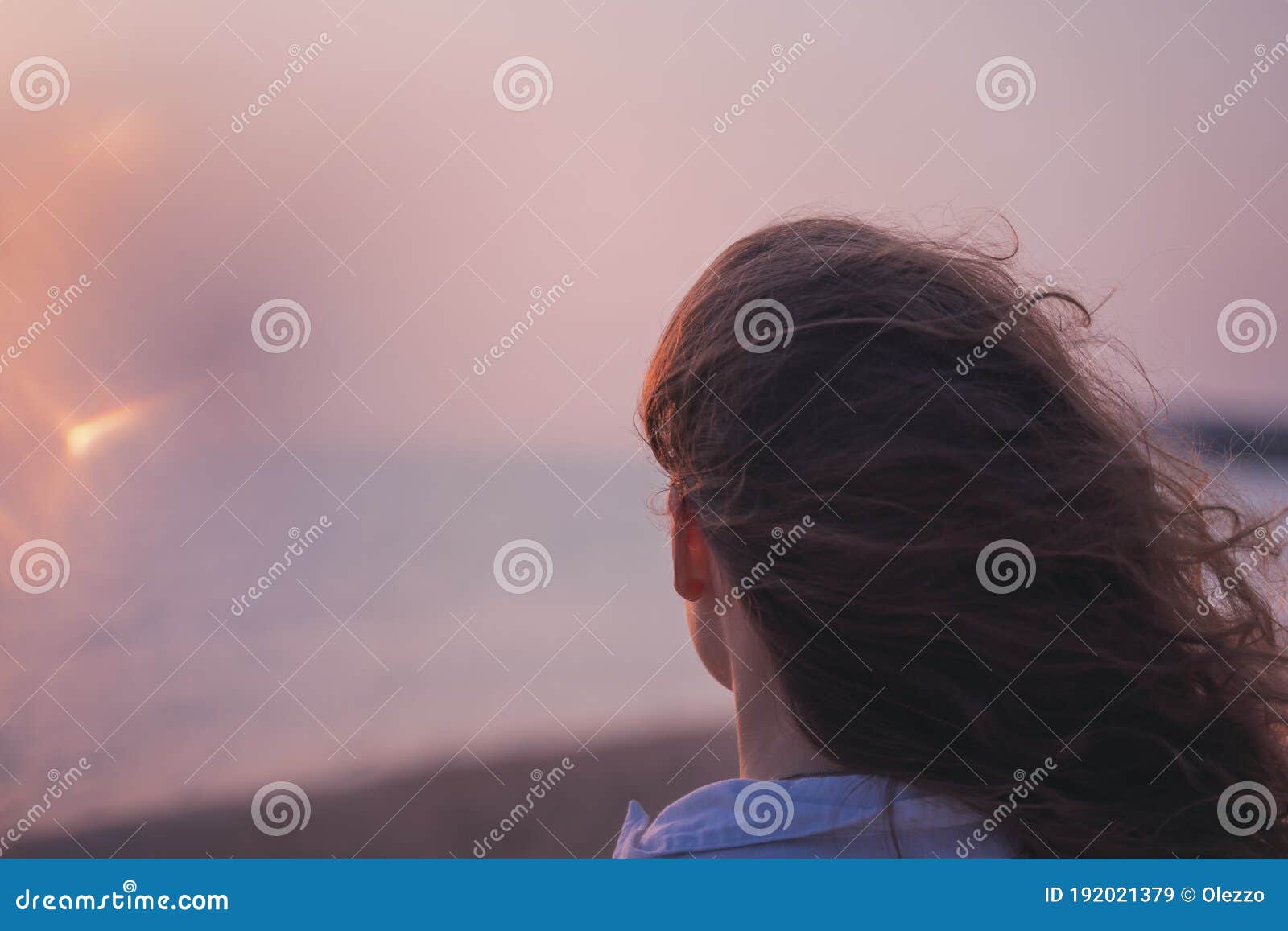 A Young Woman Looking at the Sunset at the Sea Standing with Her Back ...