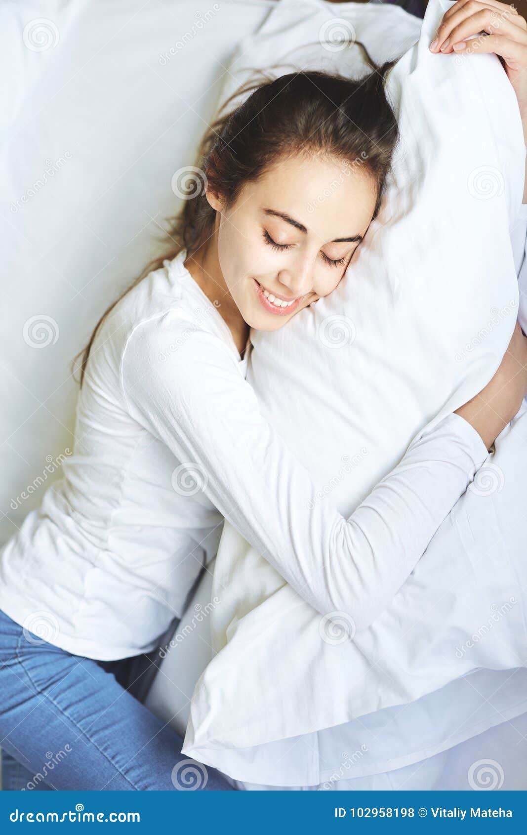 Young Woman Lying on Bed Hugging Pillow Stock Photo - Image of person ...