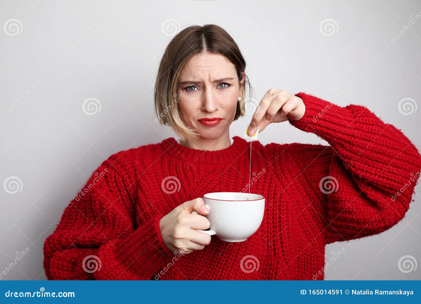 Young Woman with Negative Face Showing Tea Bagging in Her Cup. Isolated ...