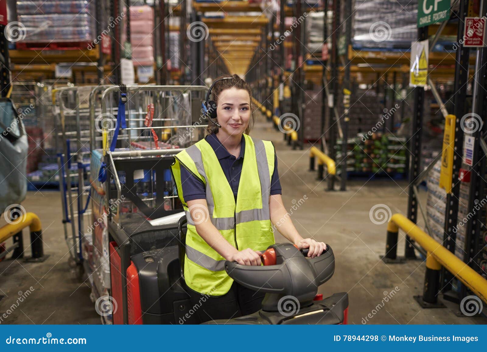 Young Woman Operating Tow Tractor in Distribution Warehouse Stock Photo ...