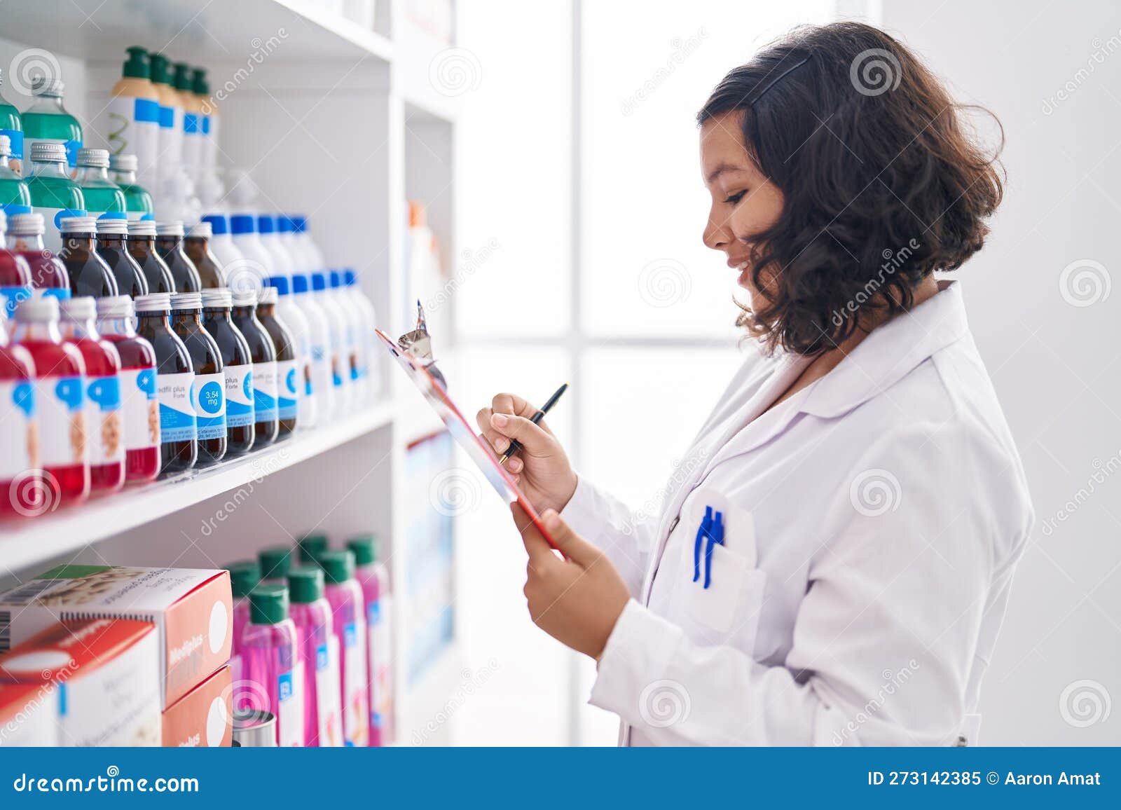 Young Woman Pharmacist Writing on Document at Pharmacy Stock Image ...