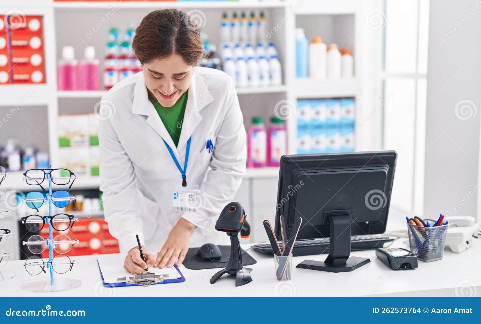 Young Woman Pharmacist Writing on Document Working at Pharmacy Stock ...