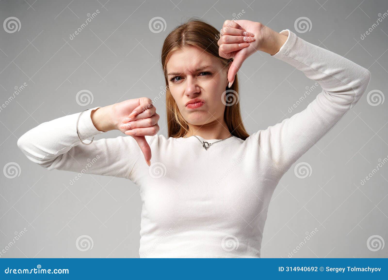 Young Woman Pointing Finger Down at Camera in Studio Stock Photo ...