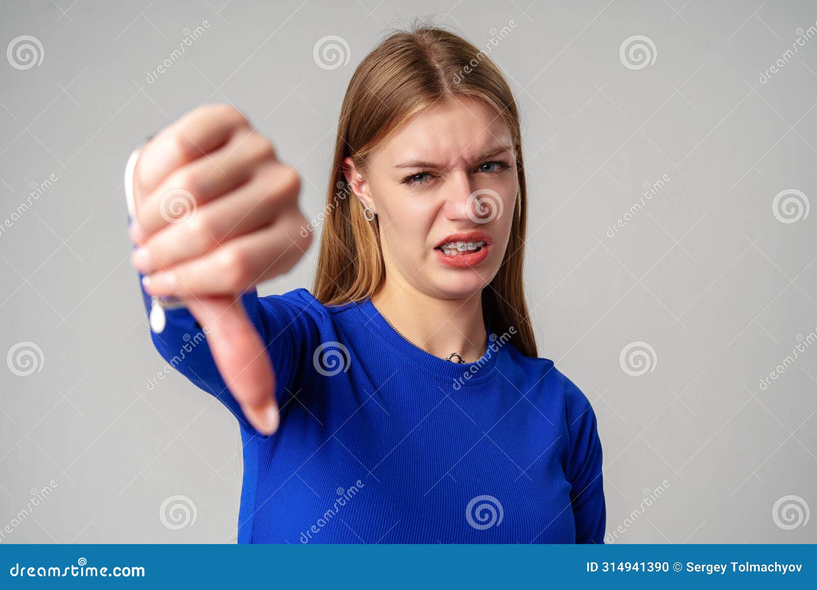 Young Woman Pointing Finger Down at Camera in Studio Stock Photo ...