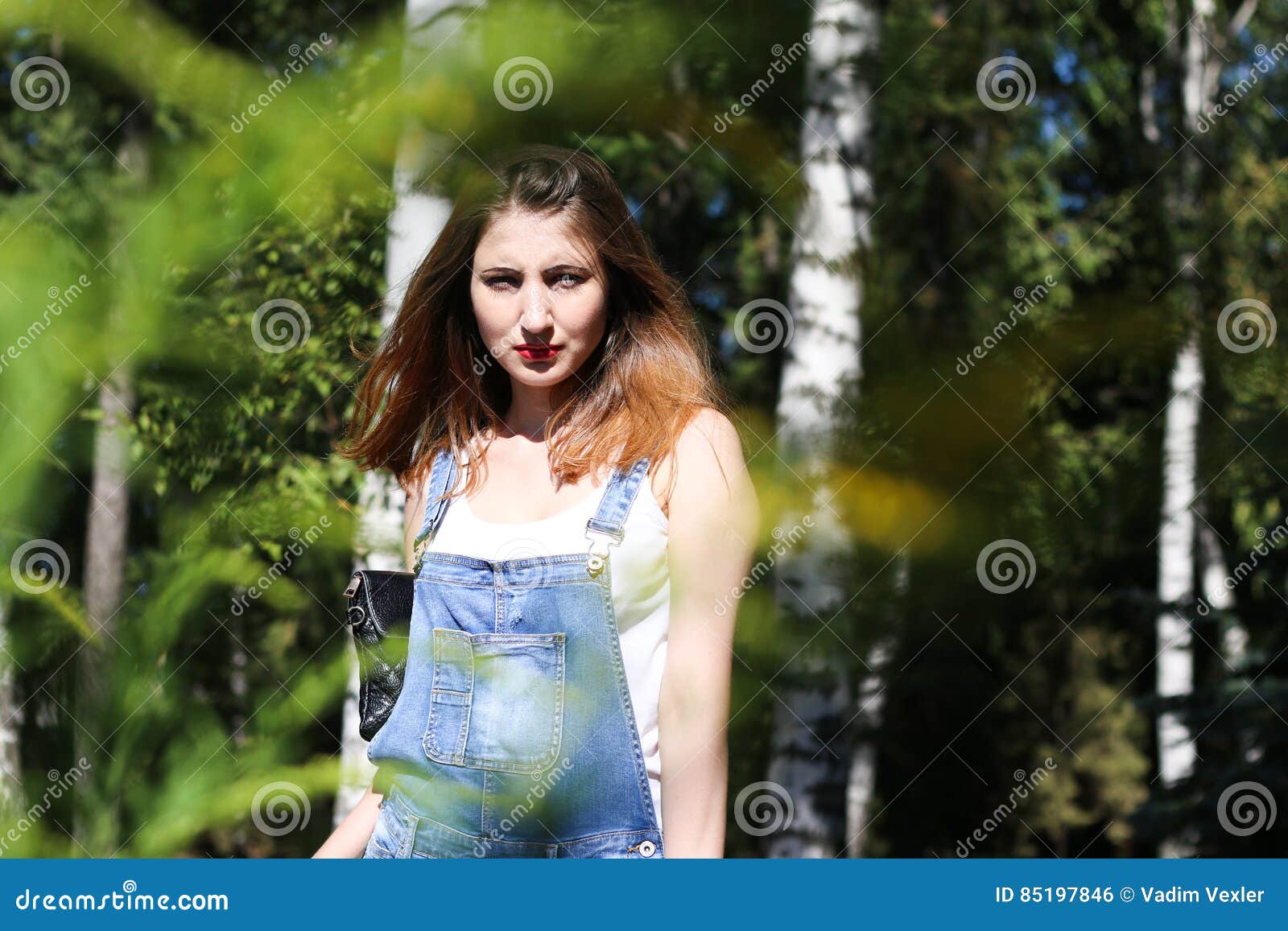Young Woman Posing on the Background, the Foreground Bushes Stock Photo ...