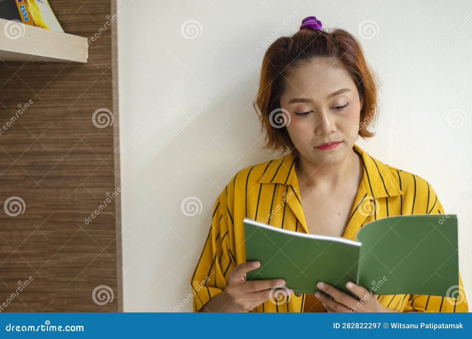 Young Woman Posing Standing and Reading a Book in the Library Stock ...