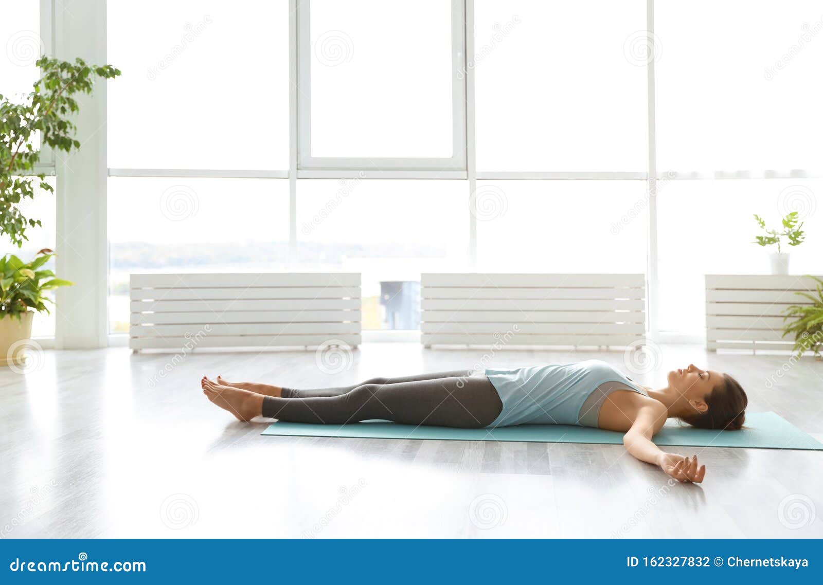 Young Woman Practicing Corpse Asana in Yoga Studio Stock Photo - Image ...