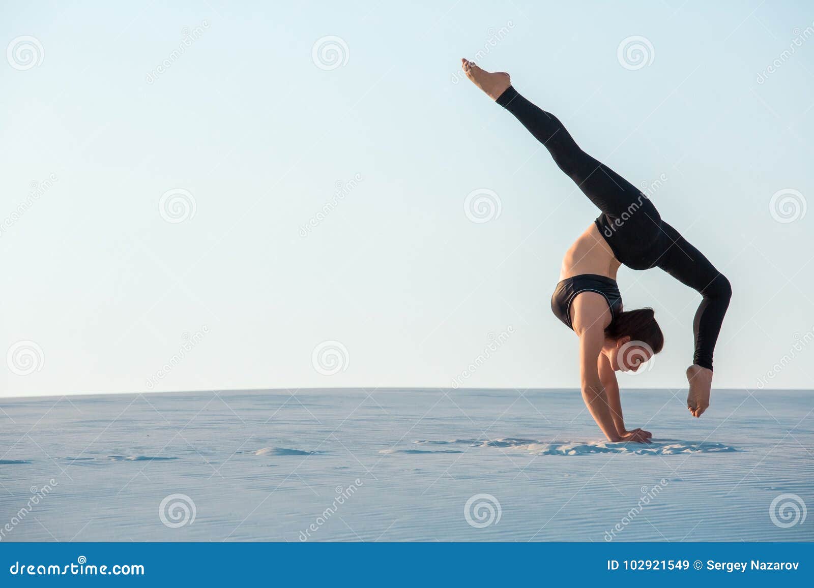 Young Woman Practicing Inversion Balancing Yoga Pose Handstand on Sand ...