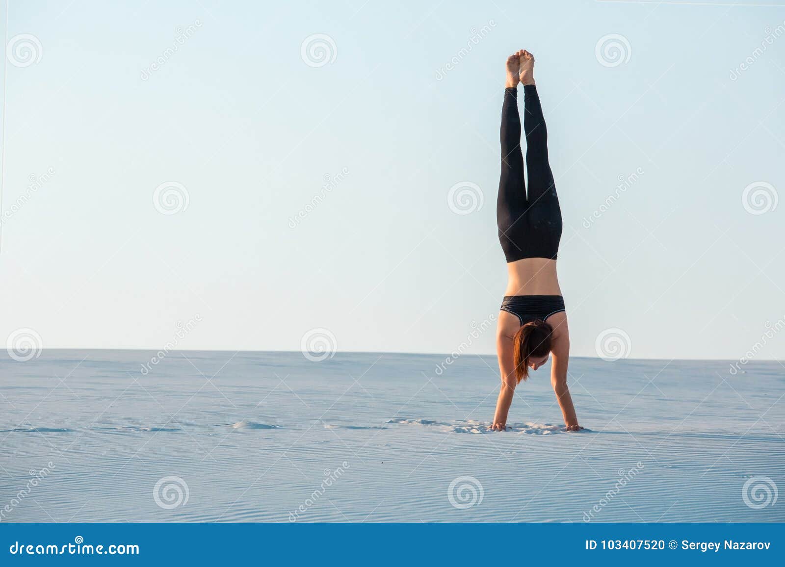 Young Woman Practicing Inversion Balancing Yoga Pose Handstand on Sand ...
