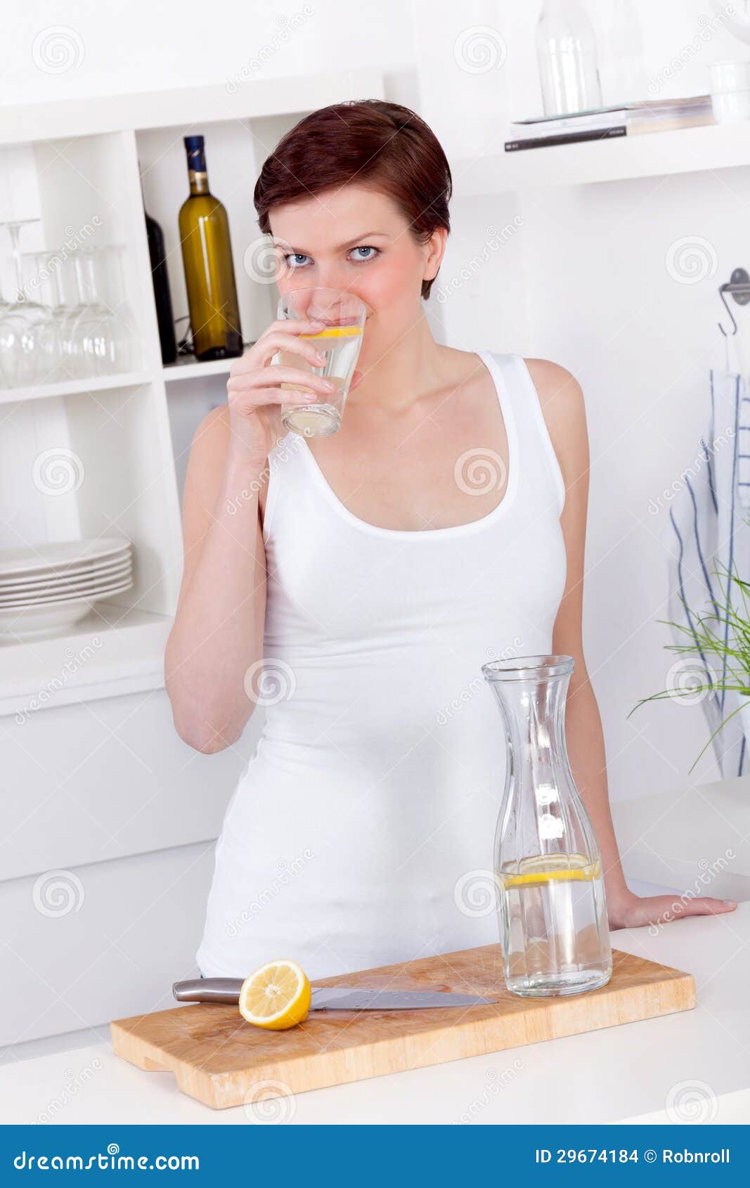 Young Woman Preparing and Drinking Lemonade in Her Kitchen Stock Photo ...