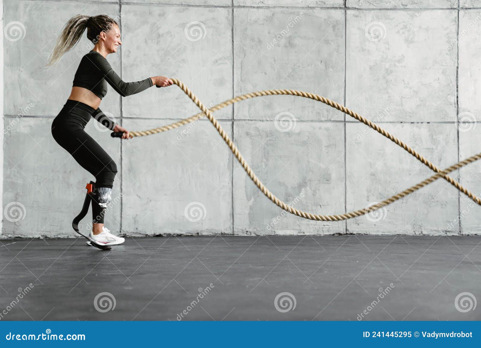 Young Woman with Prosthesis Using Battle Ropes while Working Out Stock ...
